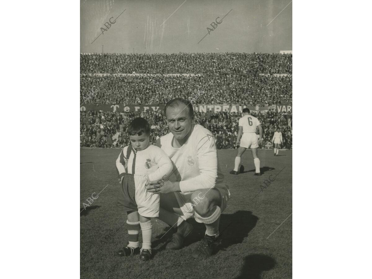 Alfredo Di Stefano posa con un niño cuya camiseta es mitad del Real ...